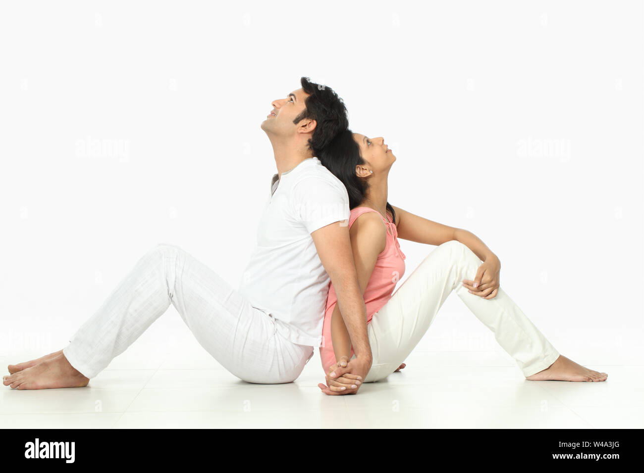 Couple sitting back to back and smiling Stock Photo - Alamy
