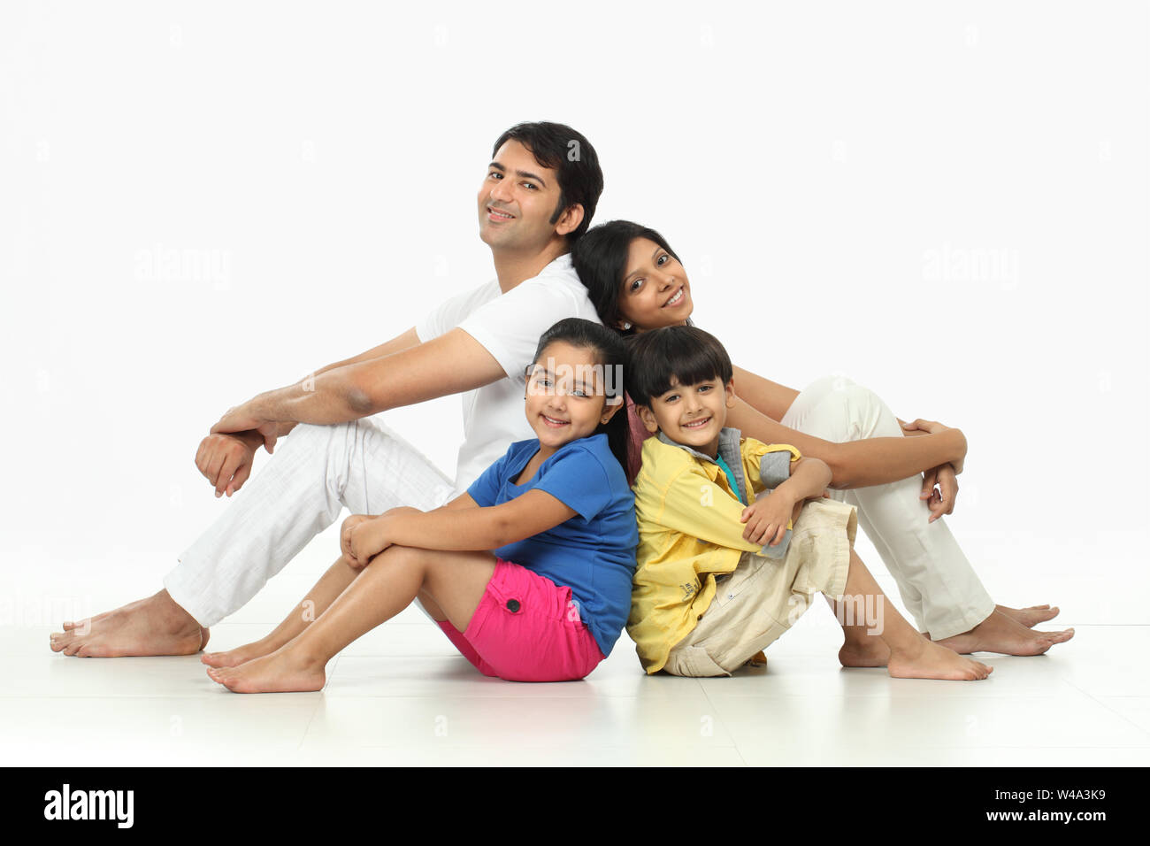 Portrait of a family sitting back to back Stock Photo - Alamy