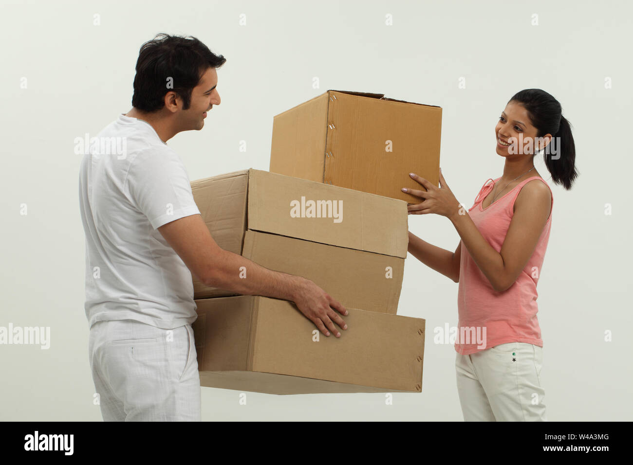 Couple carrying moving boxes into new home Stock Photo - Alamy