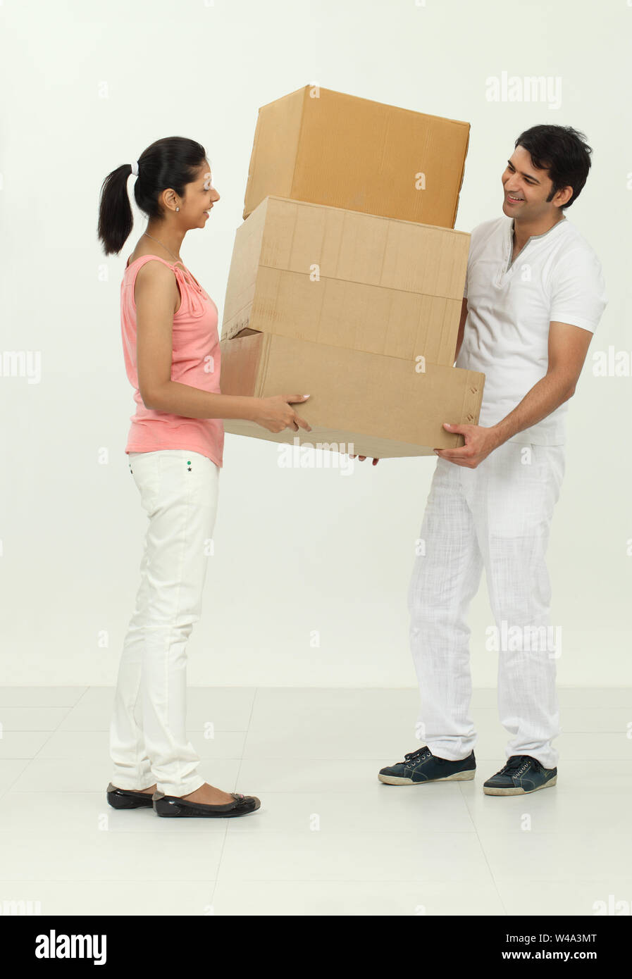 Couple carrying moving boxes into new home Stock Photo - Alamy