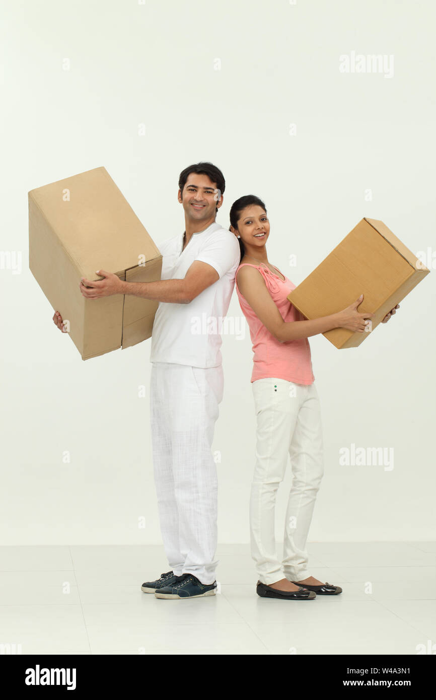 Couple carrying moving boxes into new home Stock Photo - Alamy