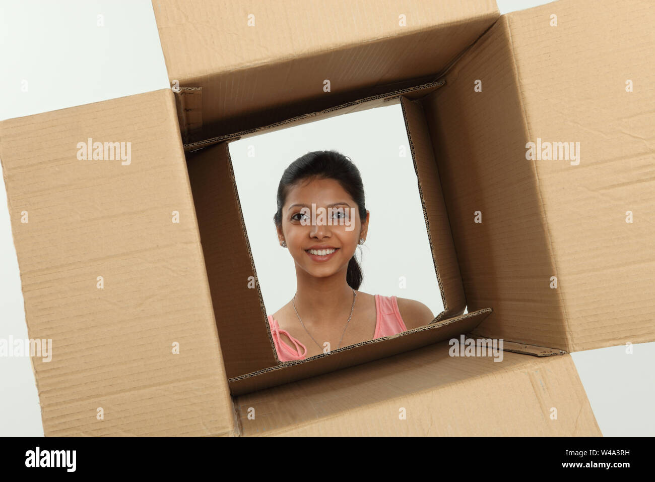 Woman looking through cardboard box Stock Photo - Alamy