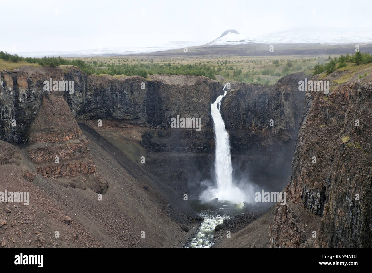 Majestic Waterfall Cascading Into Rugged Canyon Surrounded by Snow ...