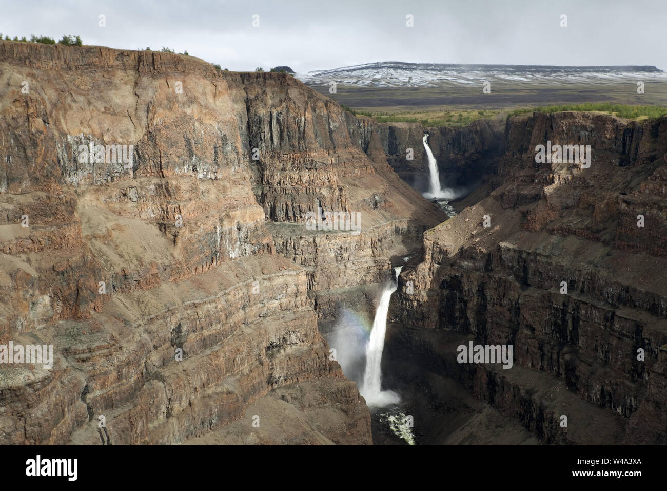 Majestic Waterfall Cascading Into Rugged Canyon Surrounded by Snow ...