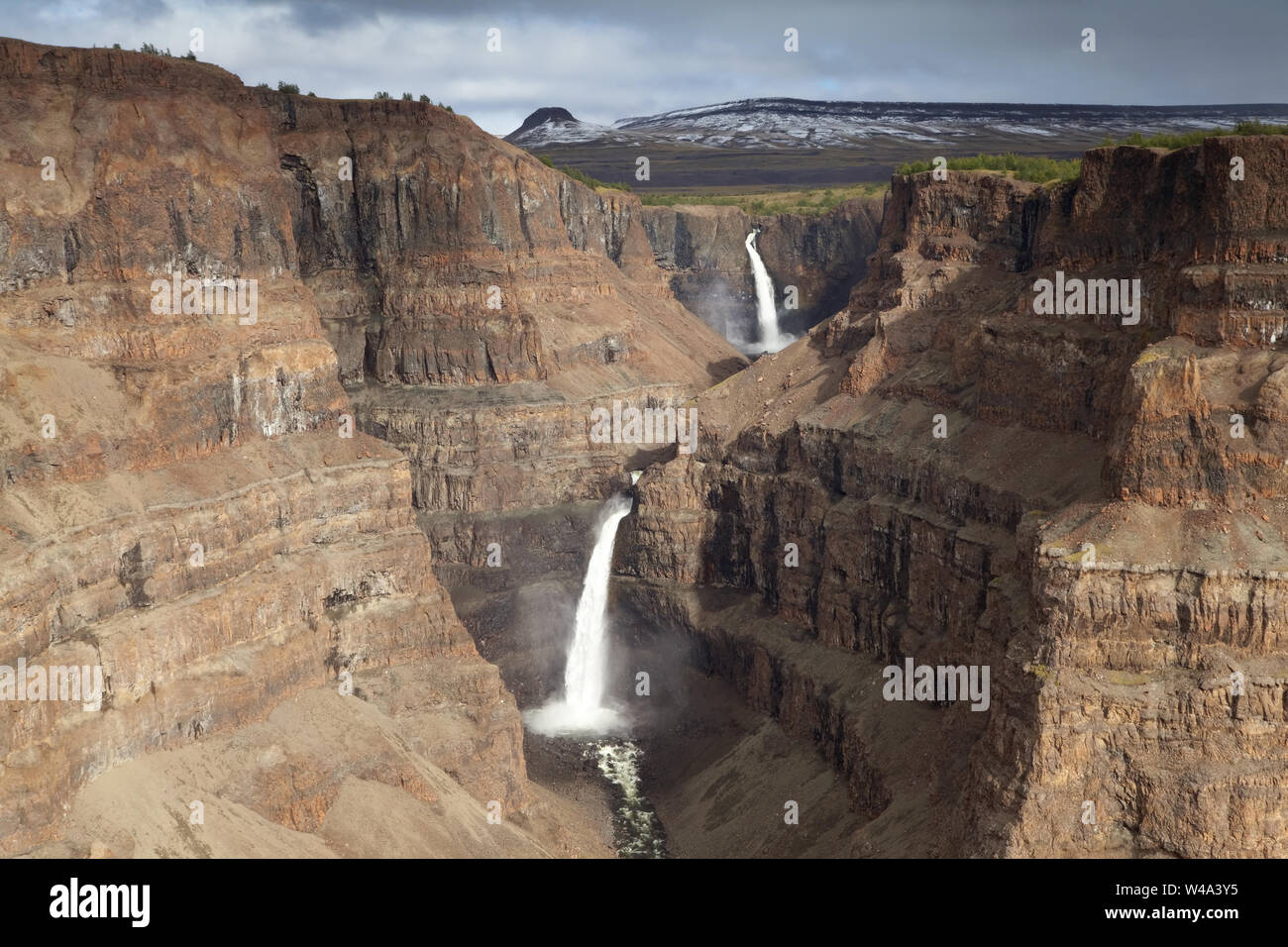 Majestic Waterfall Cascading Into Rugged Canyon Surrounded by Snow ...