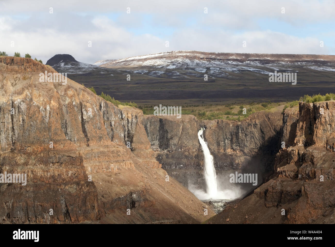 Majestic Waterfall Cascading Into Rugged Canyon Surrounded by Snow ...