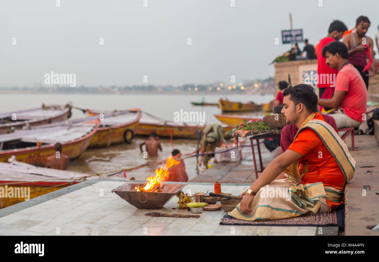 A Hindu devotee performing a religious ritual in the morning by the ...