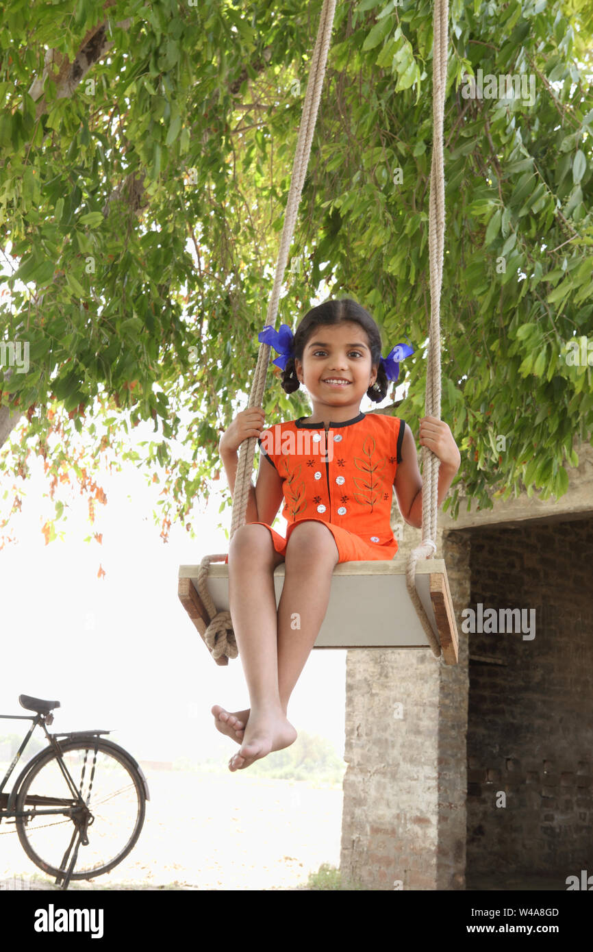 Girl swinging on a rope swing Stock Photo - Alamy