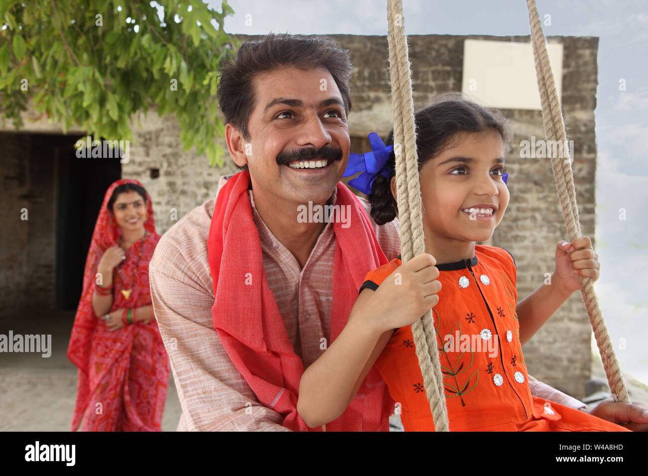 Indian man pushing his daughter on the swing Stock Photo - Alamy