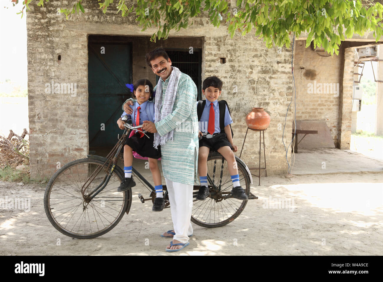 Father with two children riding on bicycle Stock Photo - Alamy