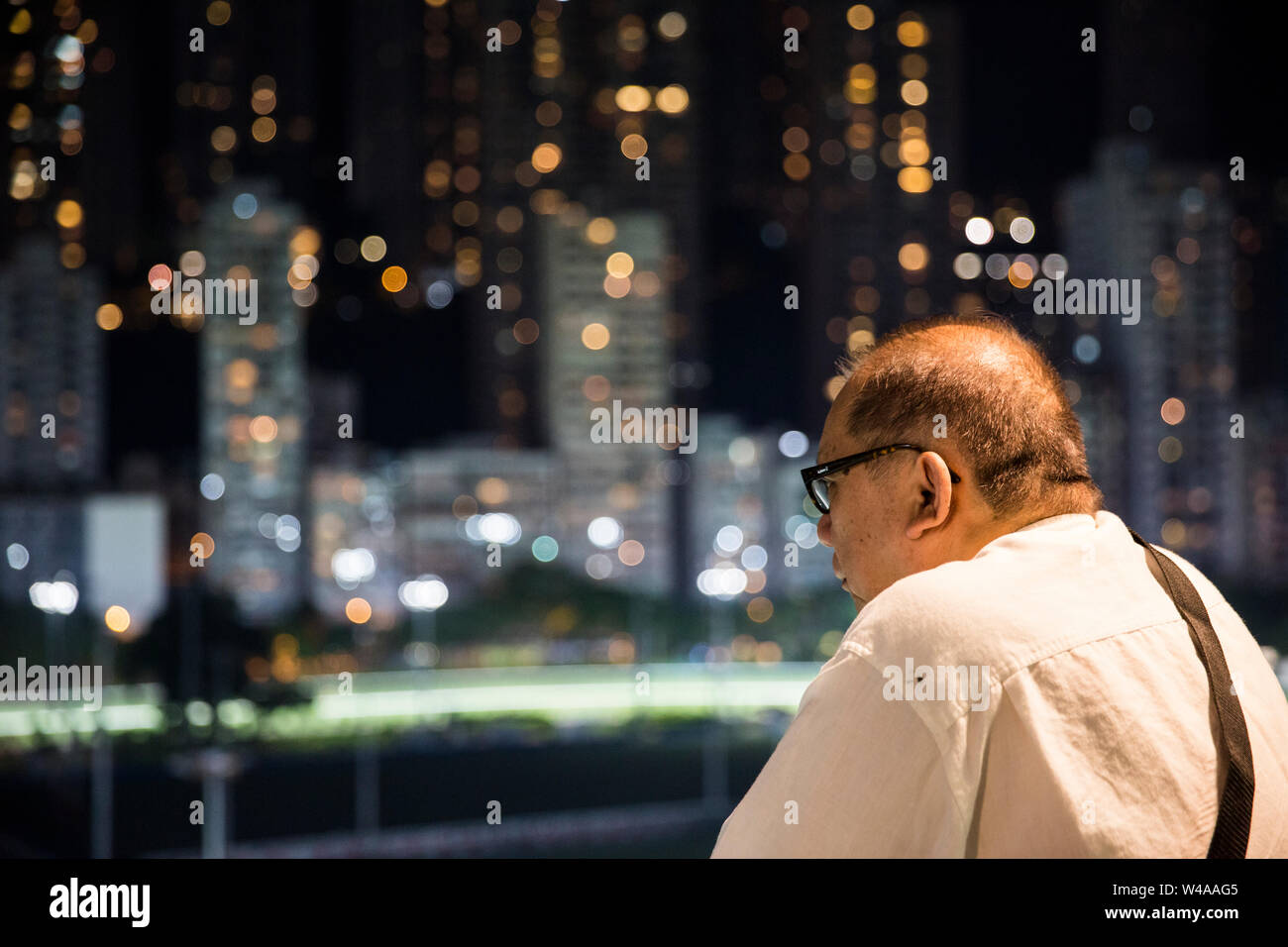 Man waiting for the next race at Happy Valley racetrack. Hong Kong ...