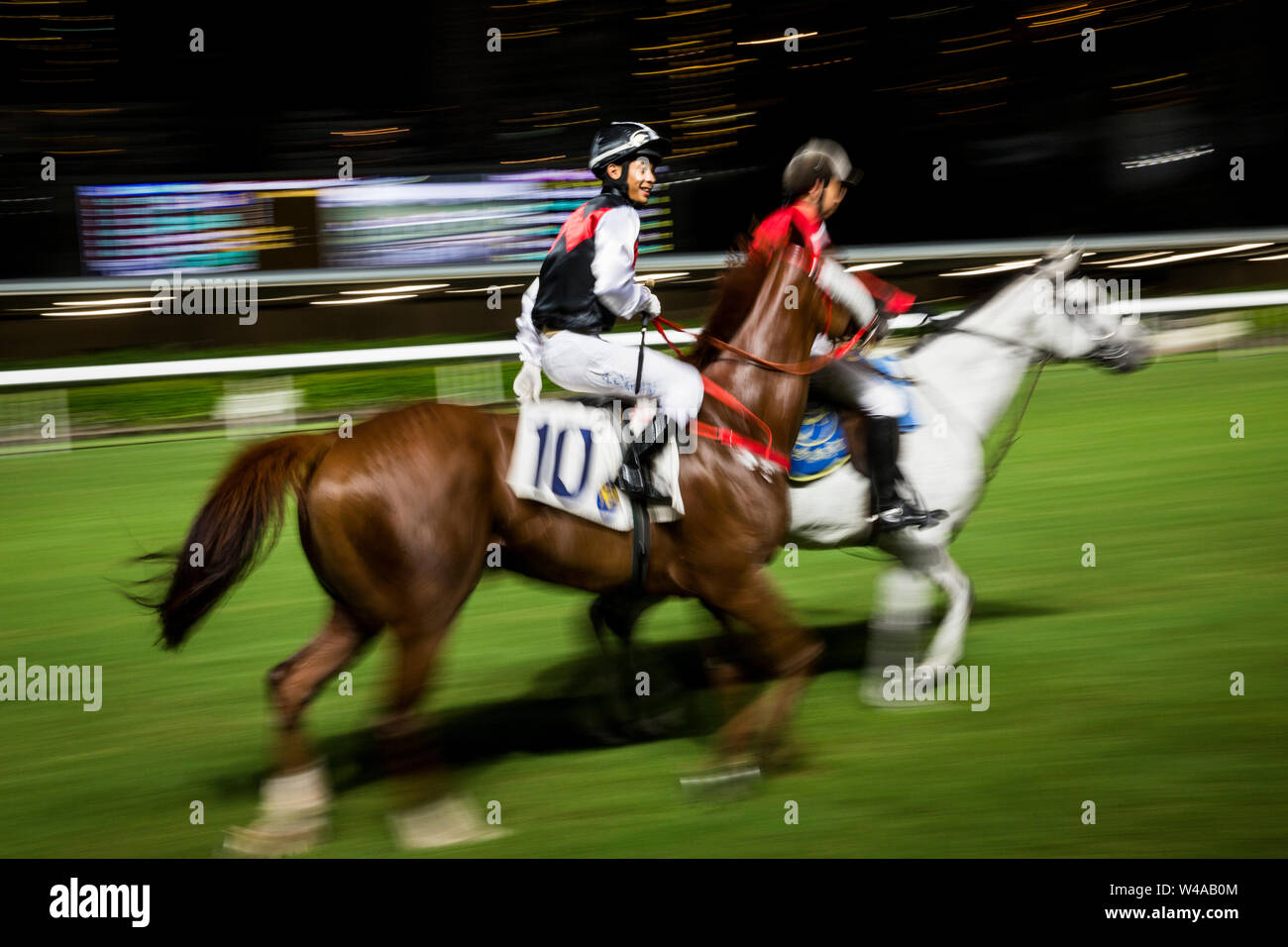 Jockey riding a race horse at Happey Valley racetrack. Hong Kong Stock ...
