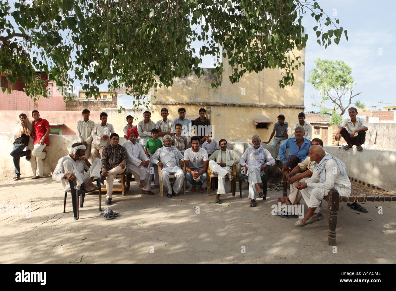Group of rural people sitting together under the tree Stock Photo - Alamy