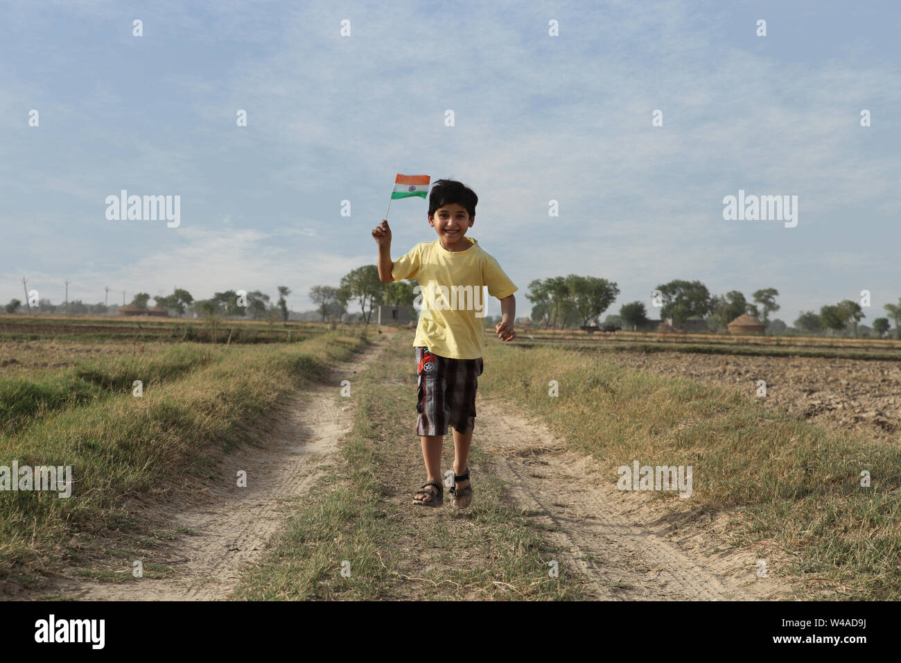 Boy running with Indian flag in a field Stock Photo - Alamy