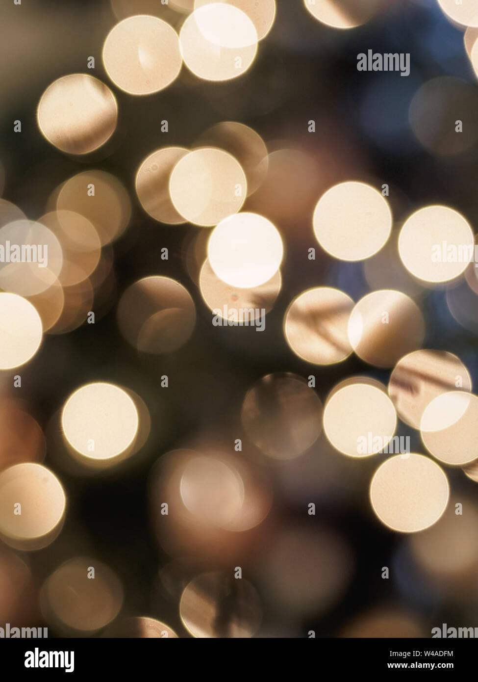Golden glow of Christmas lights in defocussed with pastel colors ...