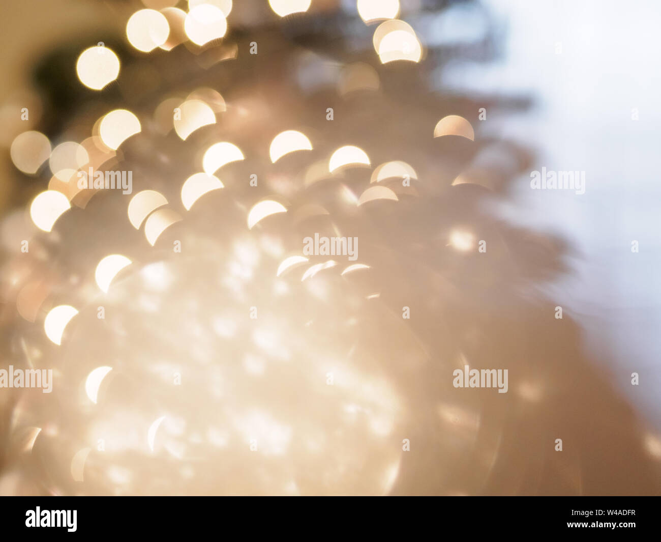 Golden glow of Christmas lights in defocussed with pastel colors ...