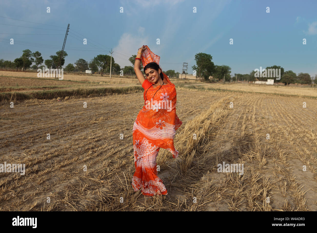 Rural woman standing and smiling in a field Stock Photo - Alamy