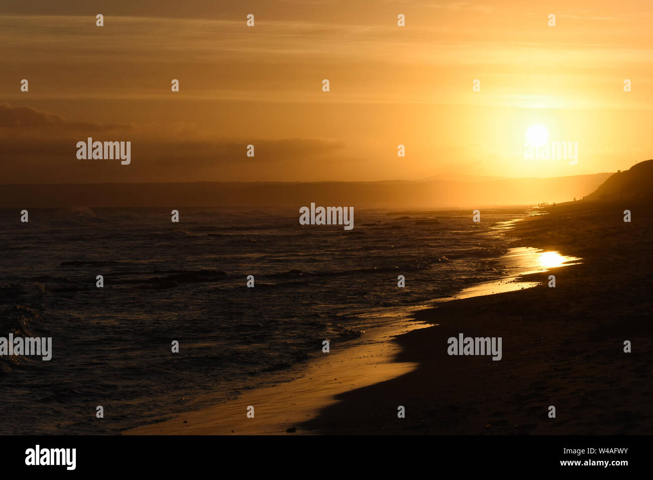 Golden Sky Sunset Shimmering On The Beach Stock Photo - Alamy