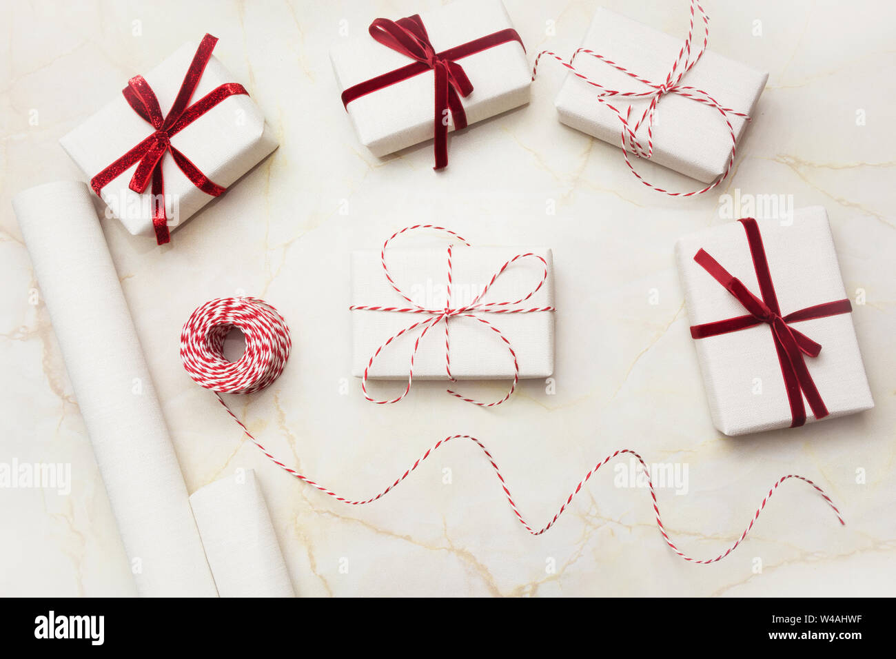 Christmas gift boxes wrapped in white craft paper and decorative red ...