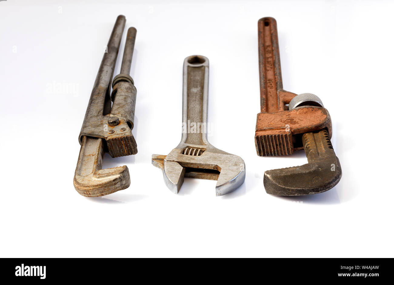 Old metal adjustable pipe wrenches horizontal and isolated on white ...