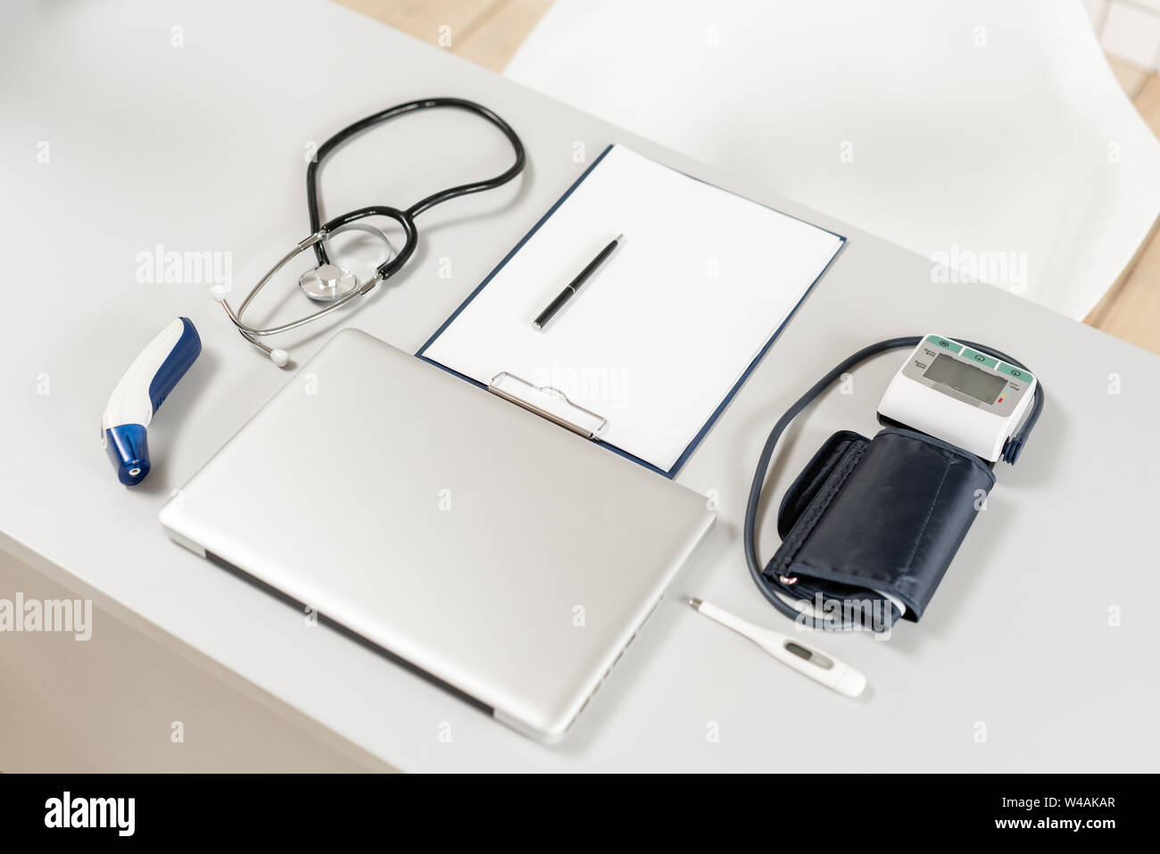 Stethoscope, measuring blood pressure and laptop on wooden desk for ...