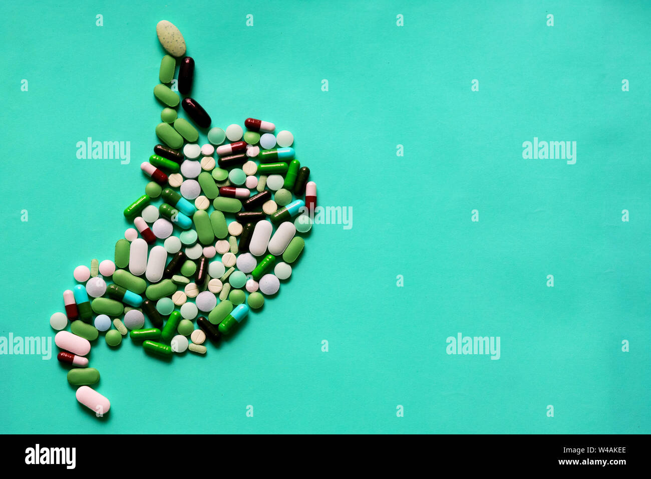 Medicine pills tablets capsules in shape of human stomach in blue ...