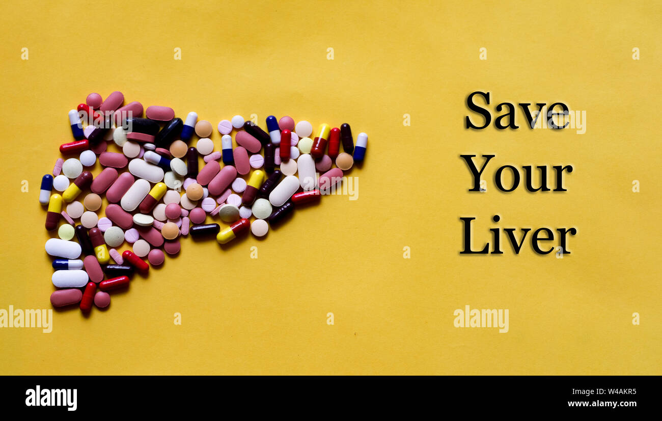 Medicine pills tablets capsules in shape of human liver in yellow ...