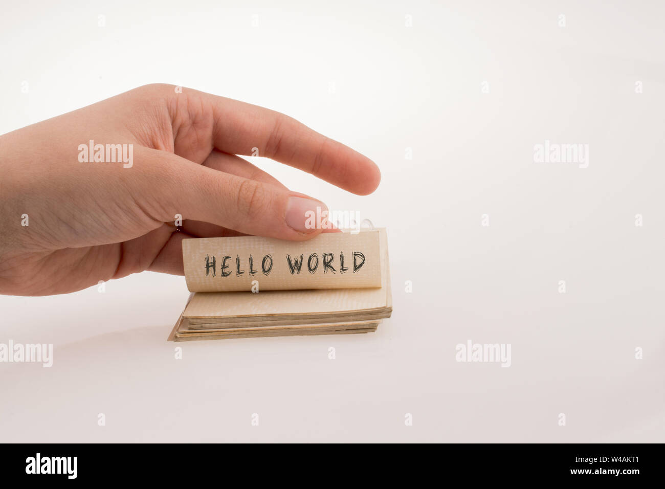 Hand holding notebook page with HELLO WORLD wording on white Stock ...