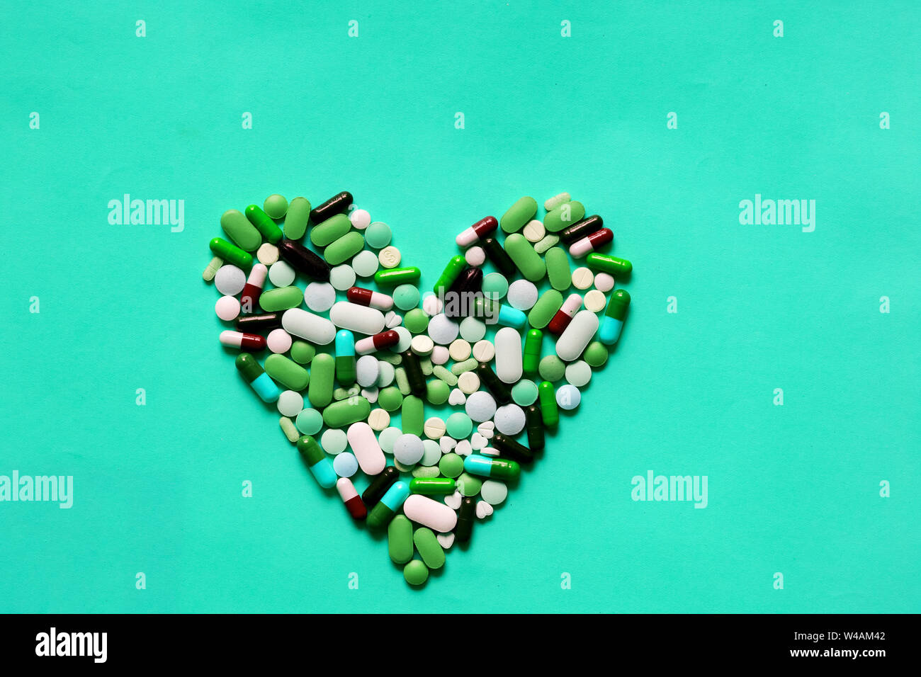 Medicine pills tablets capsules in shape of human heart in blue ...