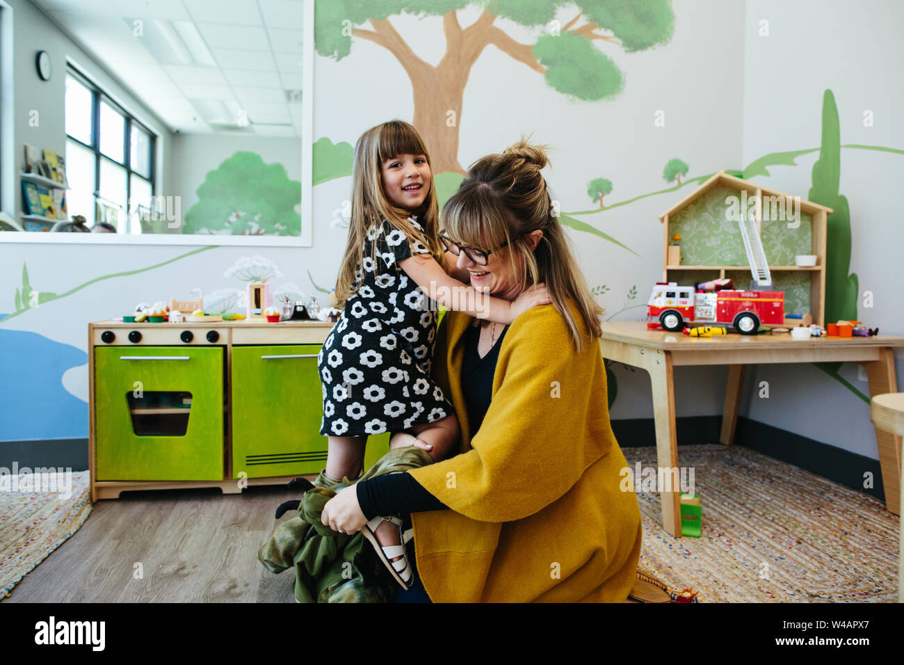 Teacher helps girl student put on a dinosaur costume Stock Photo - Alamy