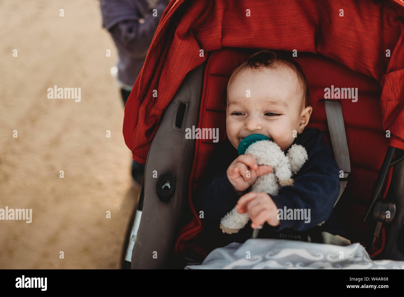 Smiling portrait of baby boy in stroller with pacifier Stock Photo - Alamy