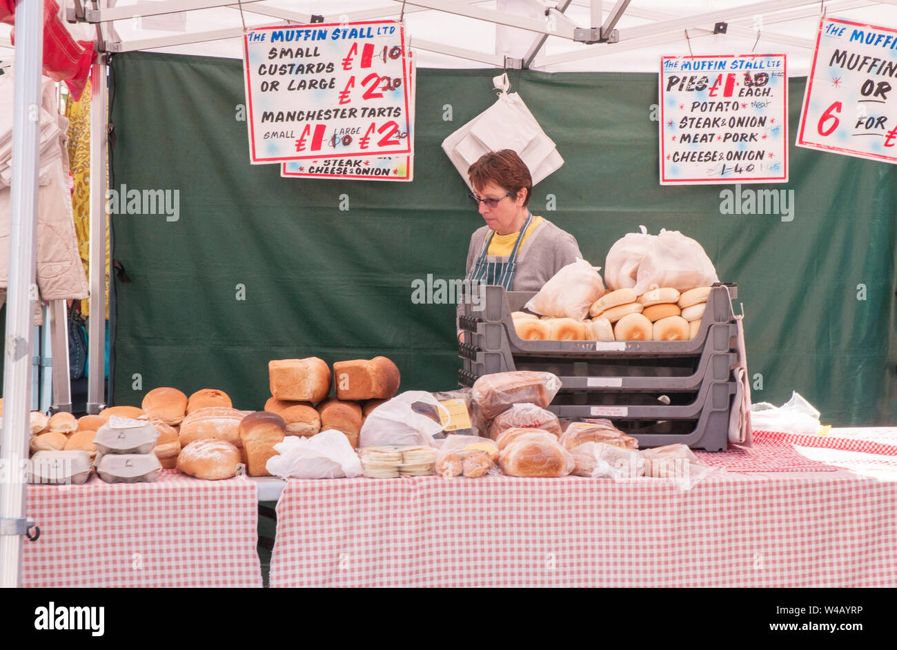 Market stall holder on the looking at various loaves of bread and ...