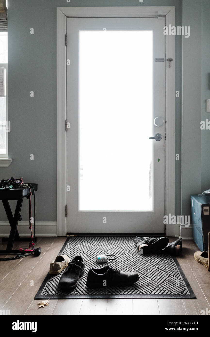 Messy shoes in front of door Stock Photo - Alamy