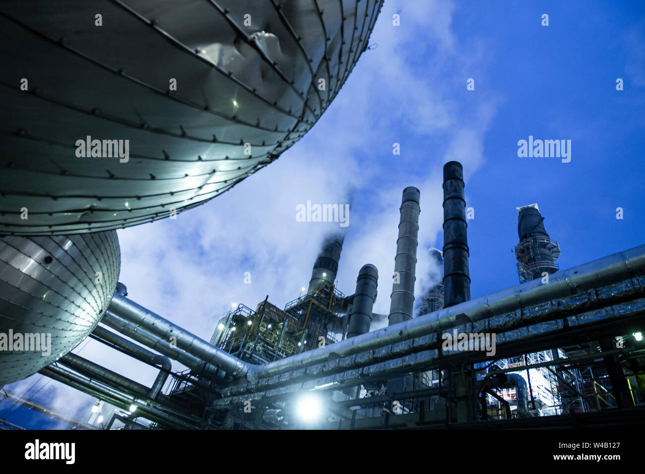 Vessels and stacks inside a refinery at night time Stock Photo - Alamy