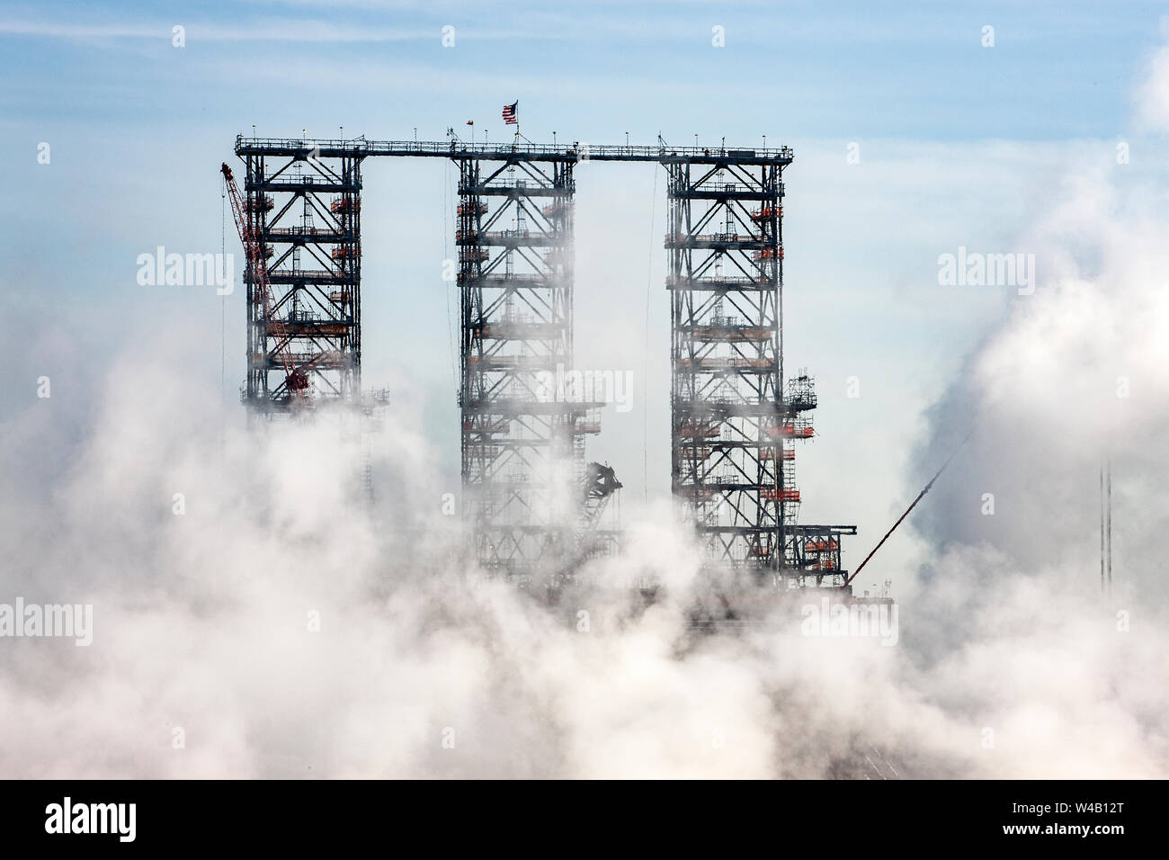 Coker rises behind steam in a refinery Stock Photo - Alamy