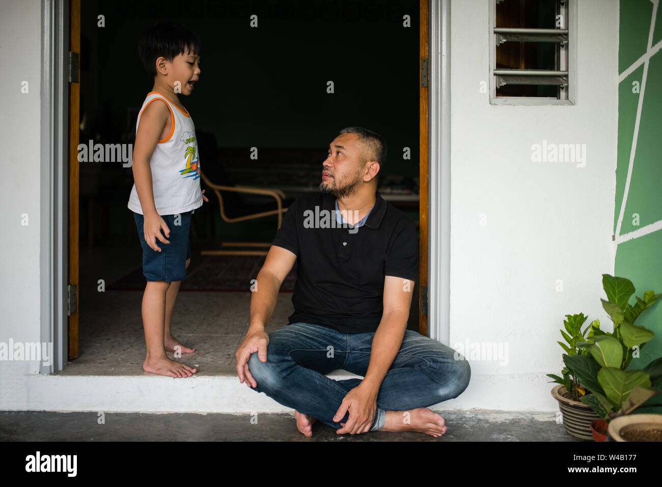 Boy talking to father at the front door Stock Photo - Alamy