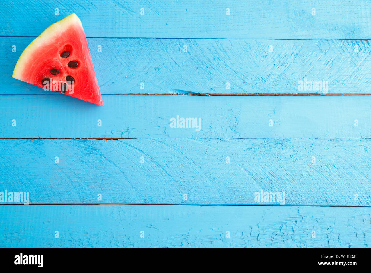 red scarlet watermelon pieces on blue wooden vintage background. summer ...