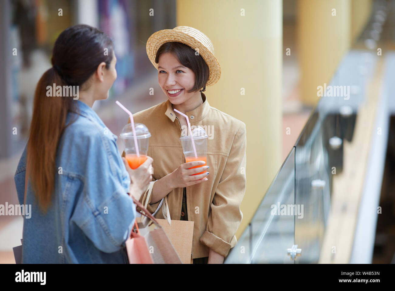 Happy excited talkative female shoppers in casual outfits standing at ...