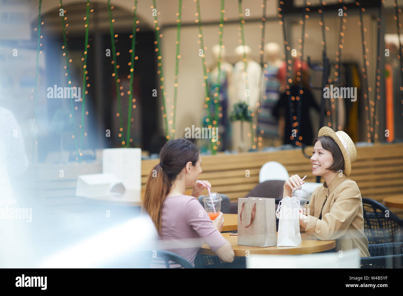 Female shoppers sitting together hi-res stock photography and images ...
