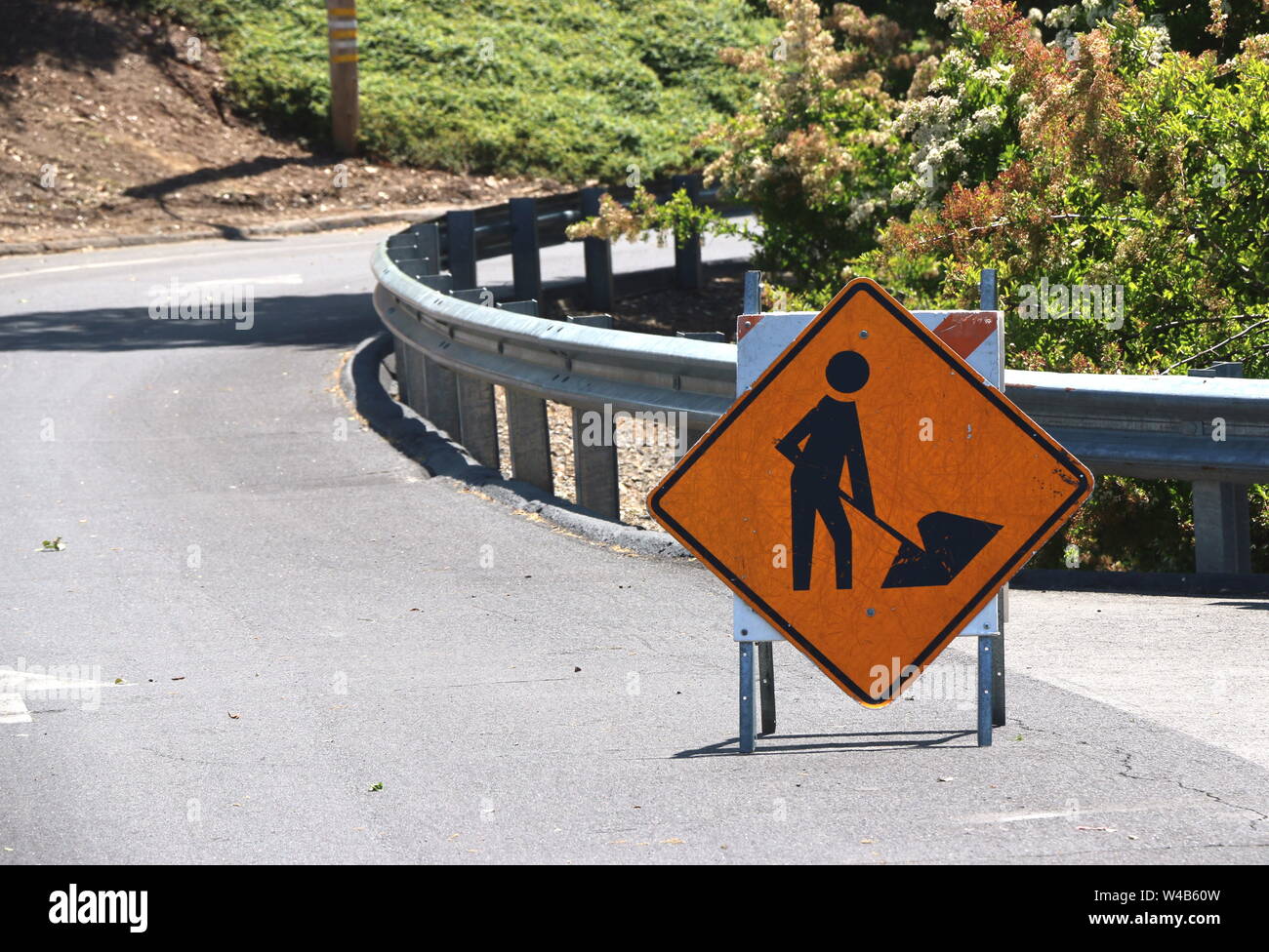 Yellow and black road sign with man with a shovel, warning of road work ...