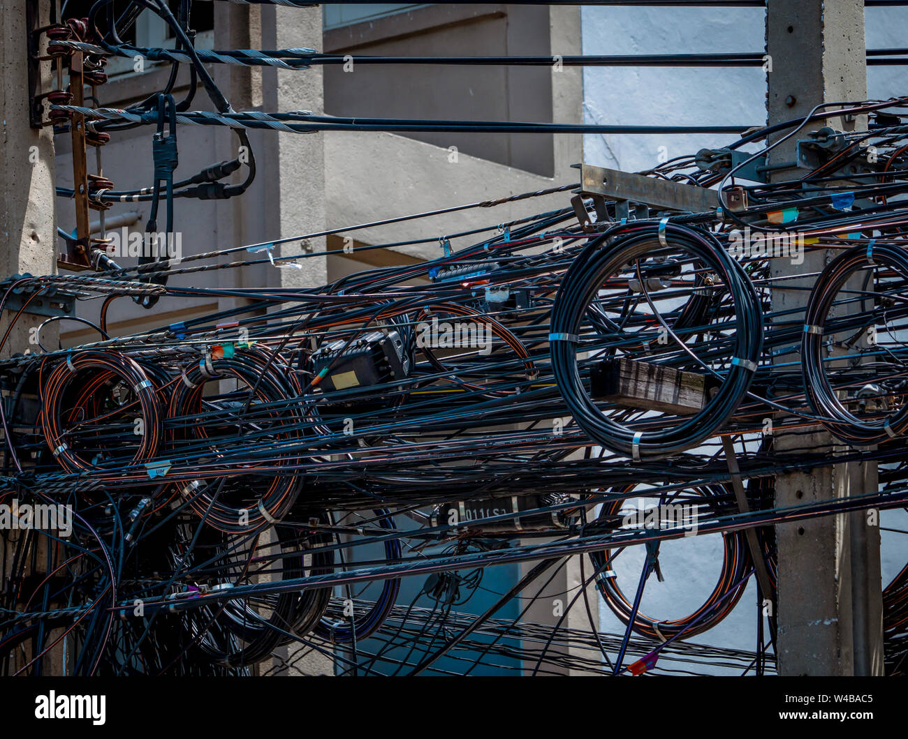 Tangled electrical wires on urban electric pole. Disorganized and messy ...