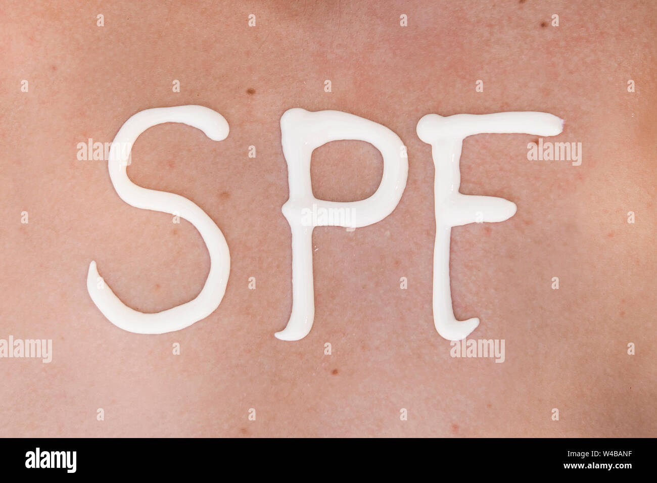 SPF word made of sunblock at woman's back at the beach. Sun protection ...