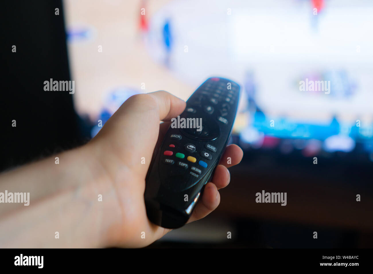 hand holding a tv remote, swithing media chanels screen Stock Photo - Alamy