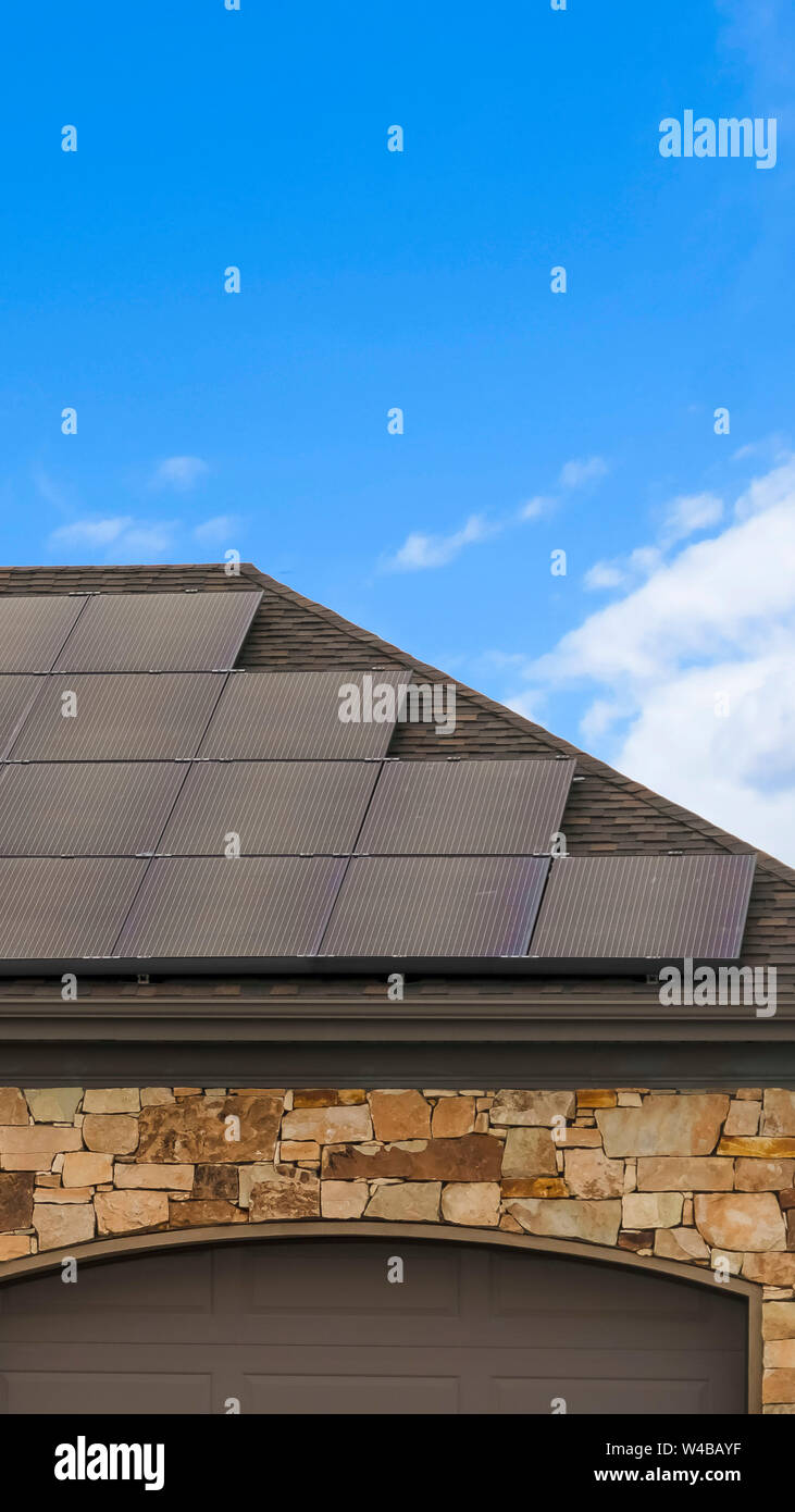 Vertical House with solar panels on the roof against blue sky with ...