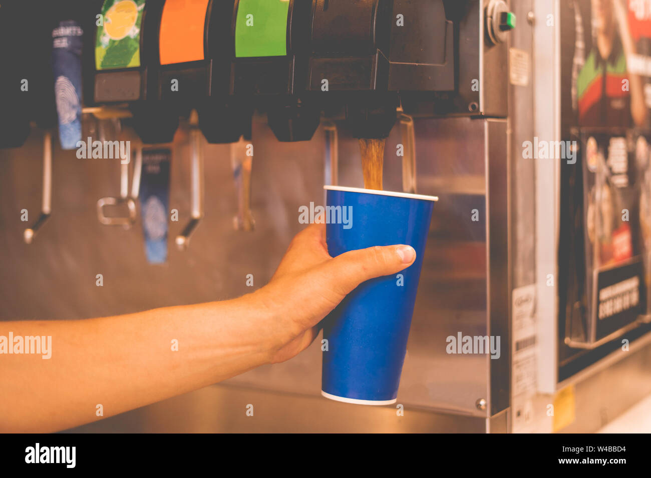 hand holding a paper glass to pour the lemonade soda soft drink machine ...