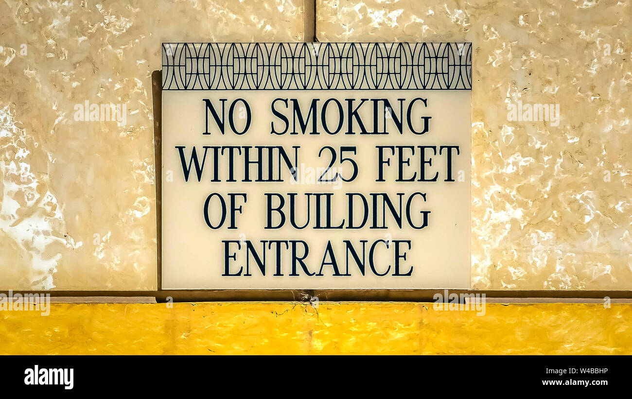 Panorama frame No smoking sign against the shiny white and golden wall ...