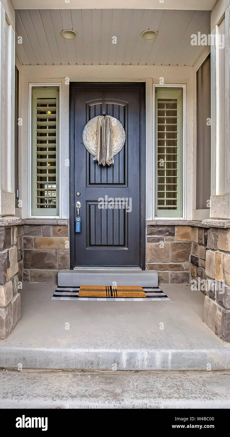 Vertical tall Home entrance with a gray front door in the middle of ...