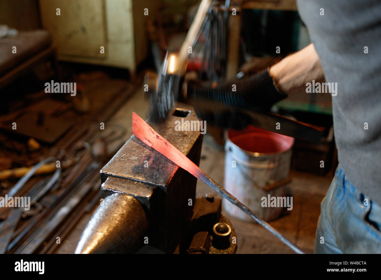 Blacksmith forging red-hot metal with hammer Stock Photo - Alamy
