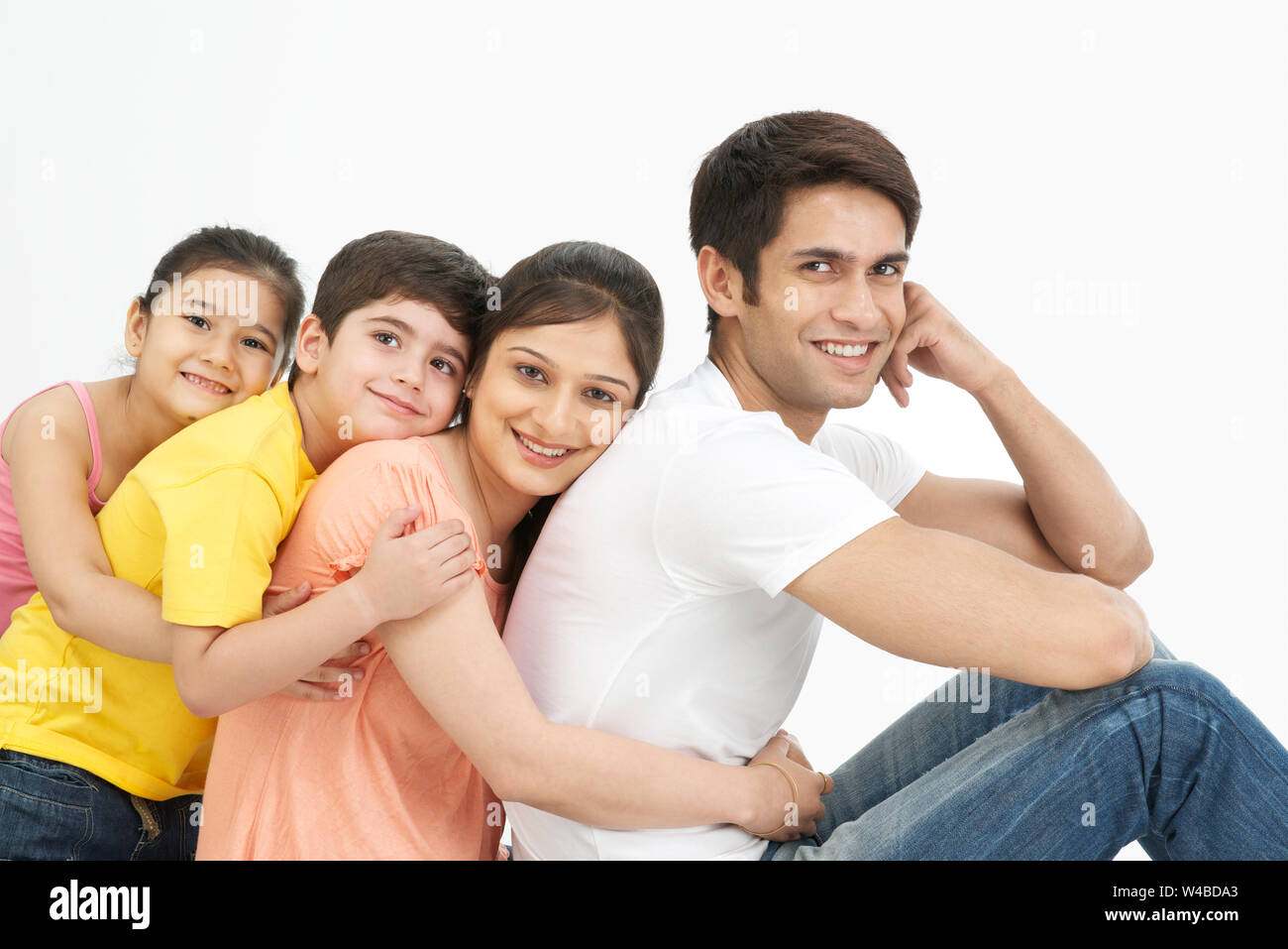 Family sitting in a row and smiling Stock Photo - Alamy