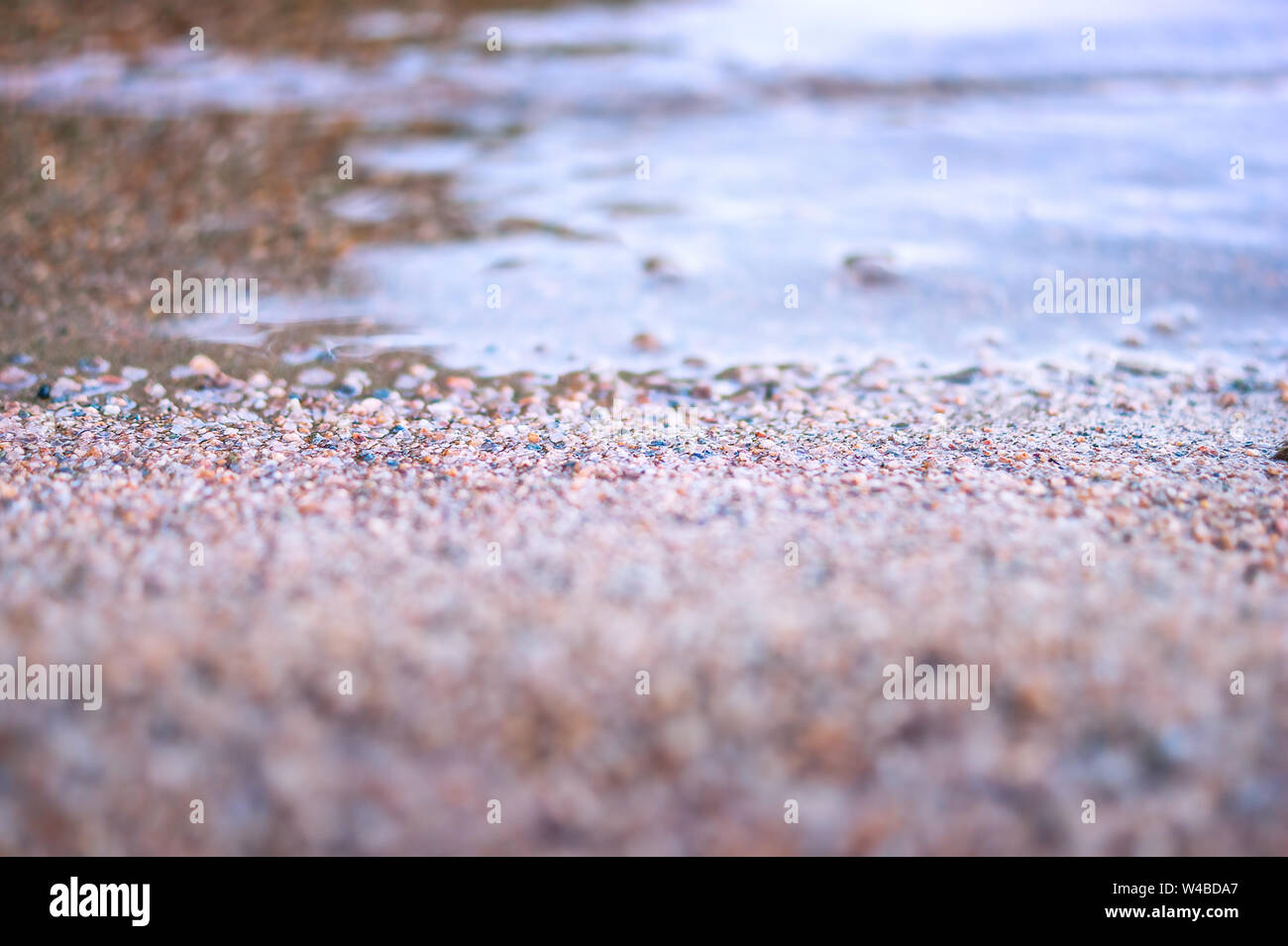 Close-up View of Wet Coarse Sand in Water Waves. Travel Concept Stock ...